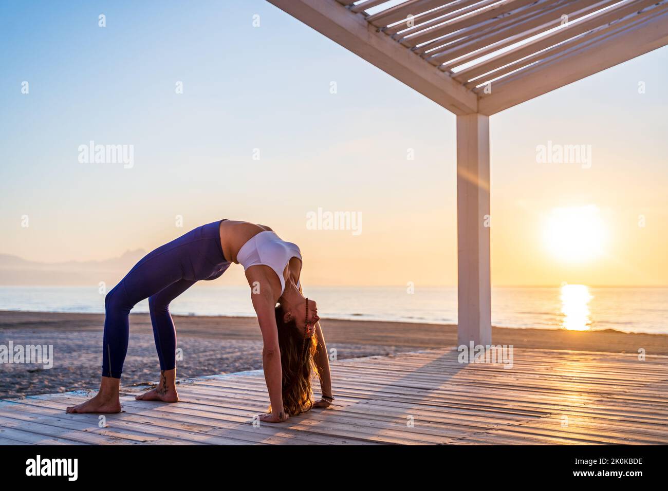 Side view of concentrated female practicing yoga while stretching your ...