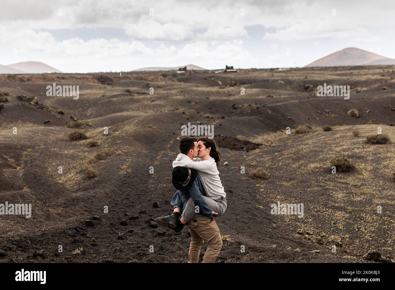 Side view of romantic young couple hugging and kissing each other while ...