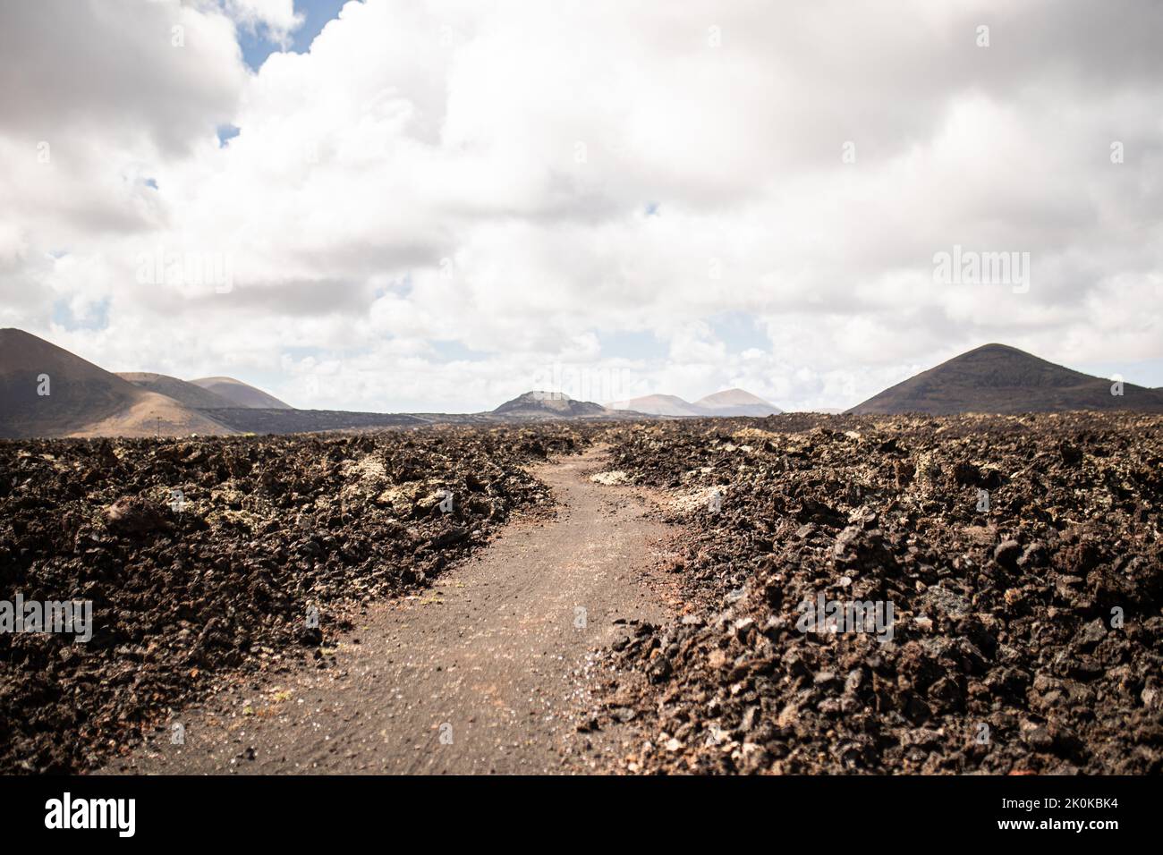 Picturesque scenery of narrow pathway amidst rough volcanic fields ...