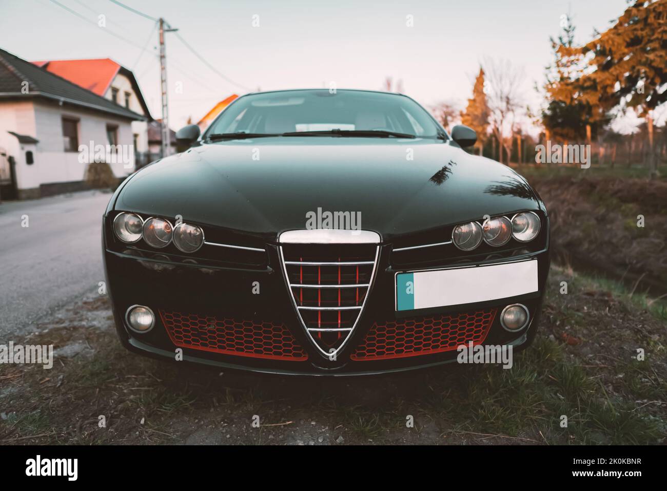 Front view of black shiny empty car parked in quiet area on wide ...