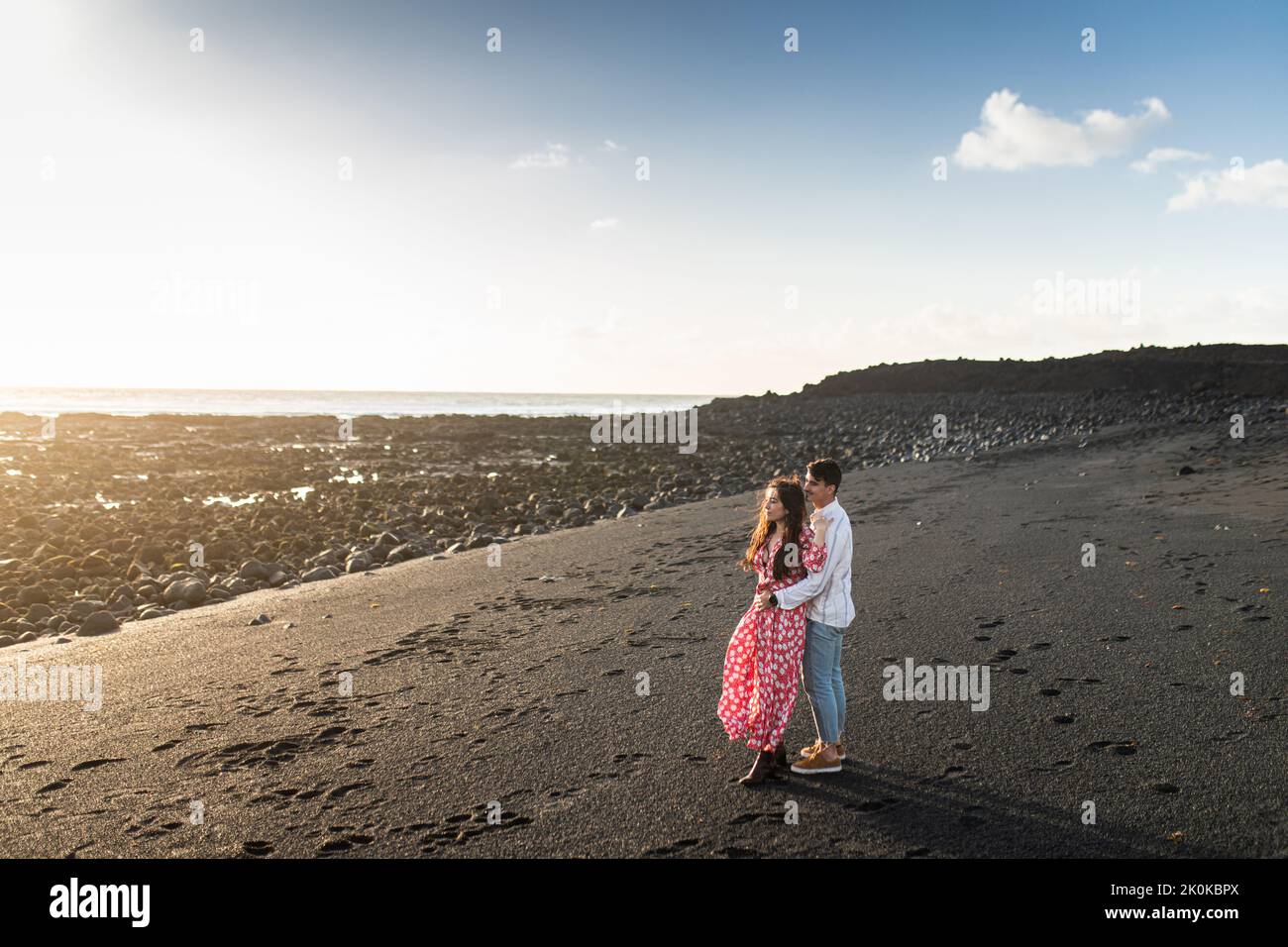 Side view of happy young ethnic male in stylish dress hugging back of ...