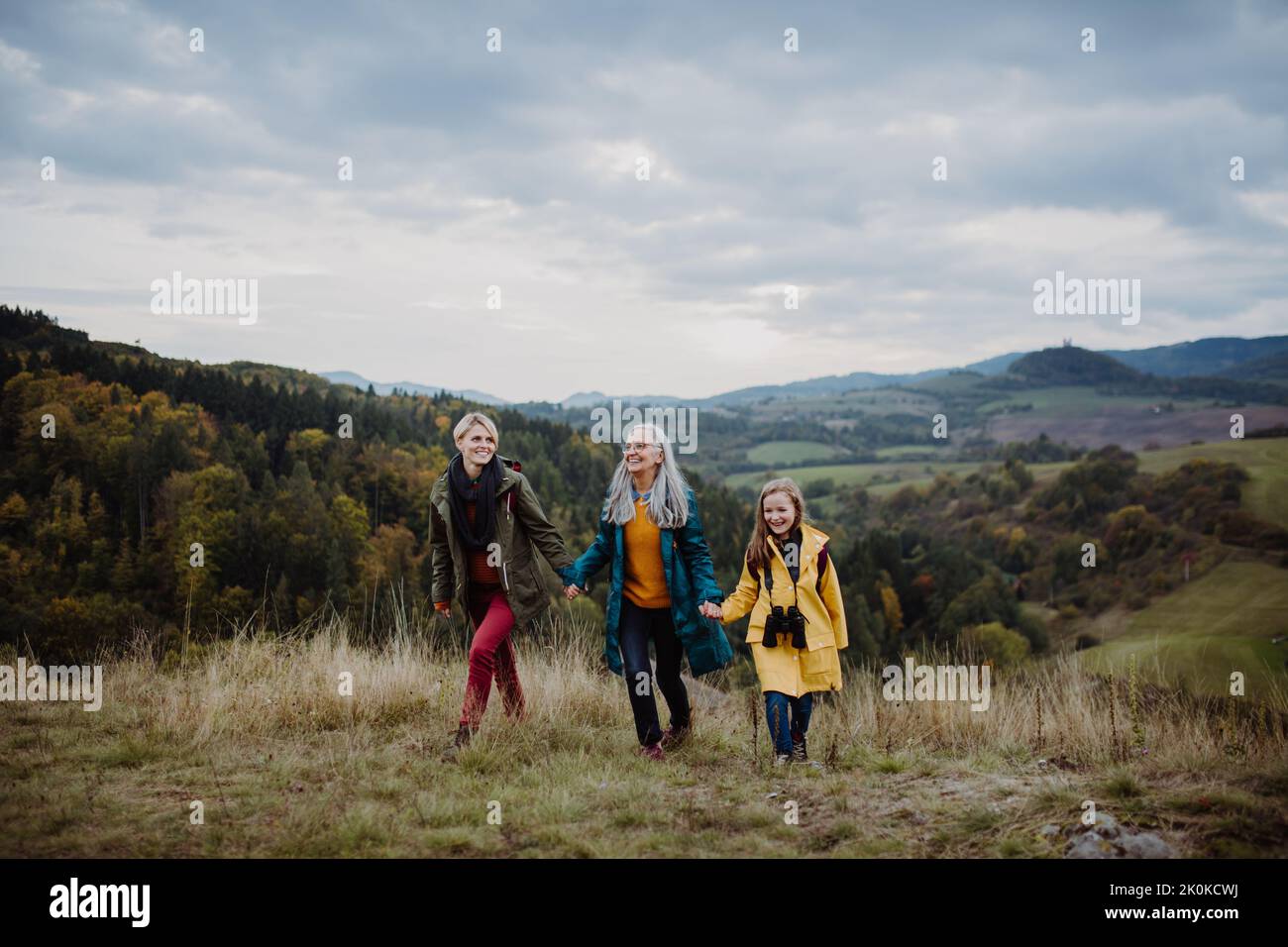Small girl with mother and grandmother hiking outoors in nature Stock ...