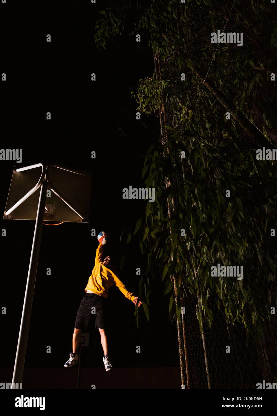 Basketball player in yellow sport clothes jumping and making dunk while ...