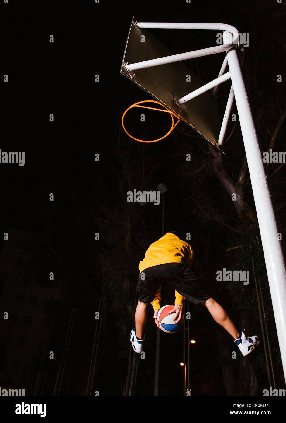 Basketball player in yellow sport clothes jumping and making dunk while ...