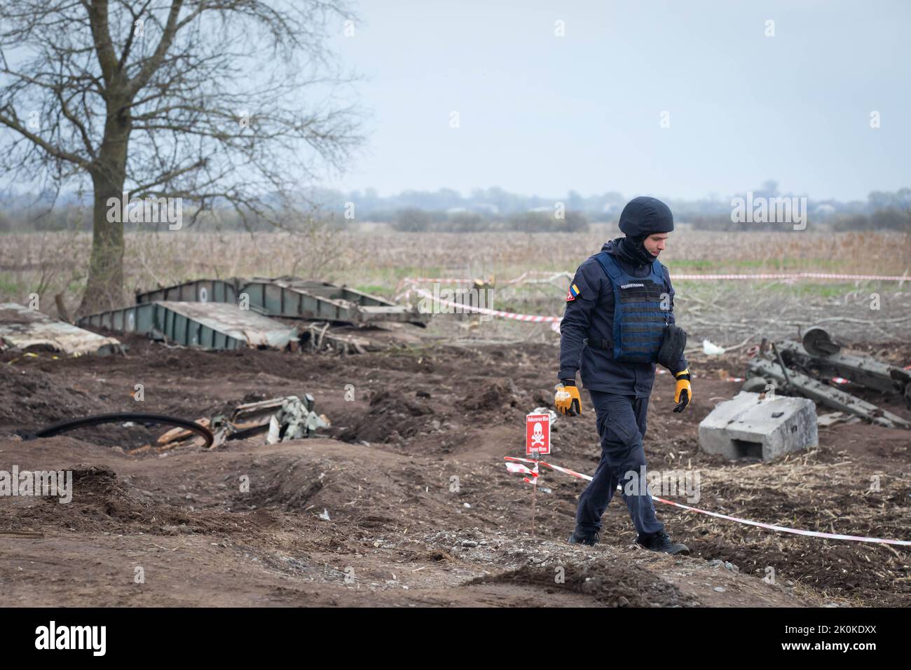 Ukrainian sapper inspects a field near a destroyed Russian pontoon ...