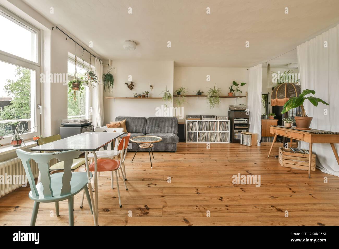 Table with chairs located near lounge area and kitchen in spacious room ...