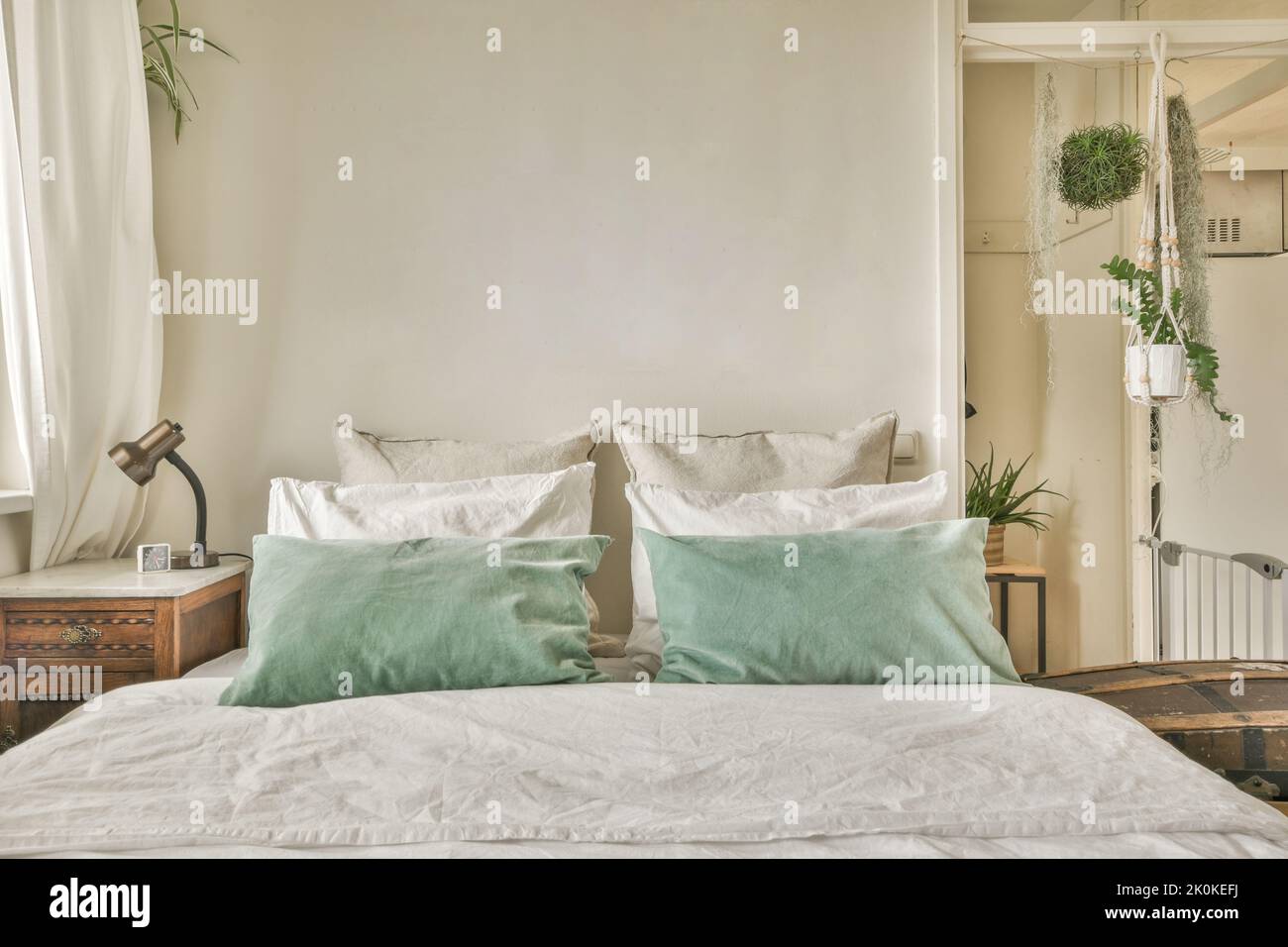 Retro bedside table and lamp located near comfortable bed and shelf ...