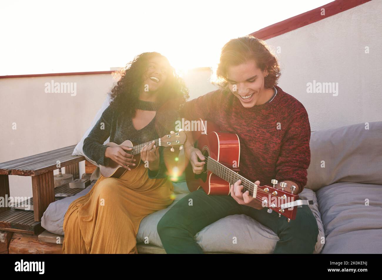 Excited young multiethnic friends in casual wear playing acoustic ...