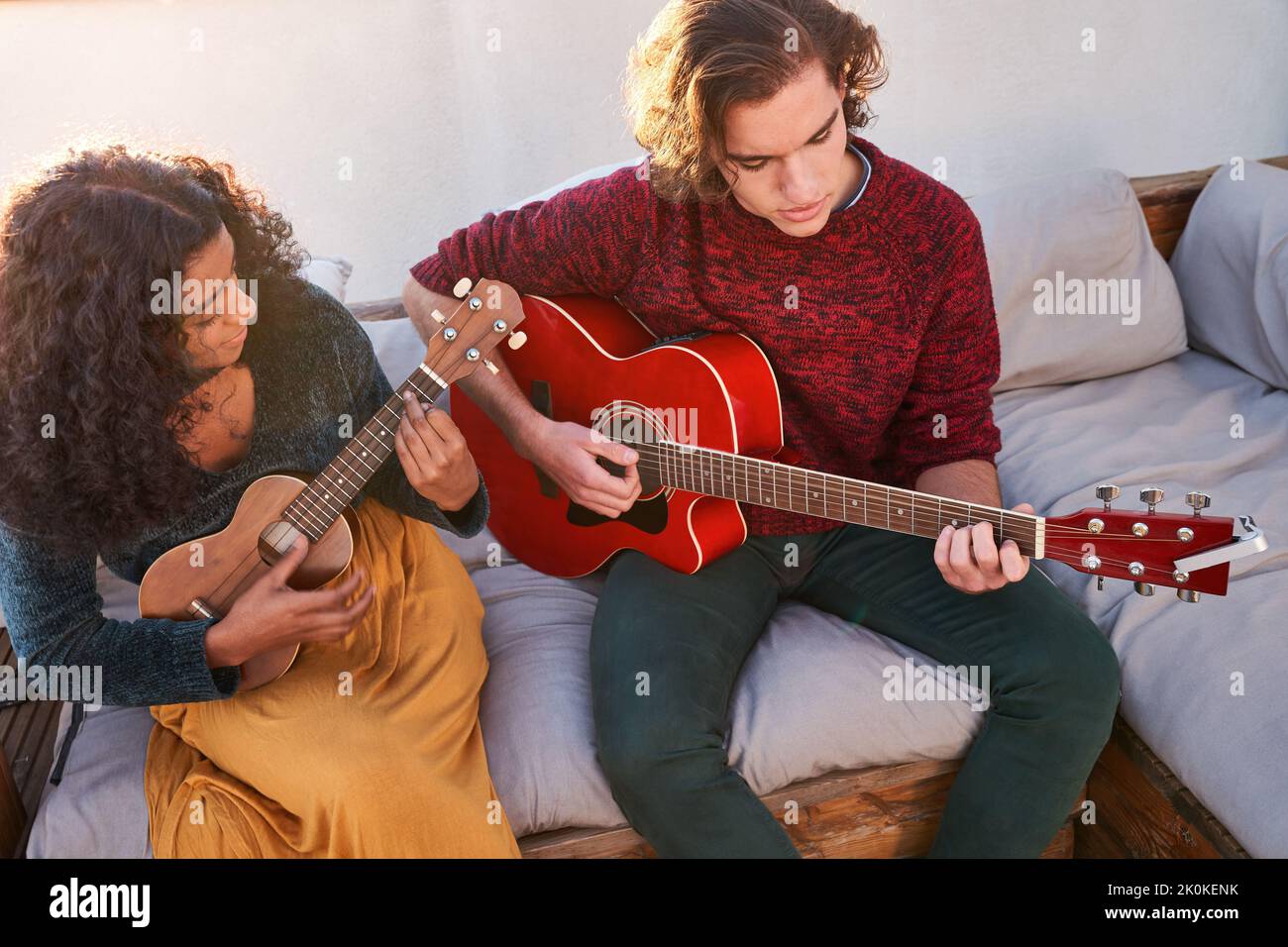 Excited young multiethnic friends in casual wear playing acoustic ...