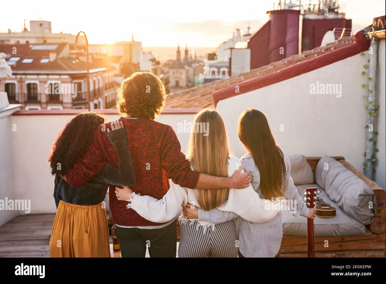 Back view faceless friends in back lit wearing casual wear embracing ...