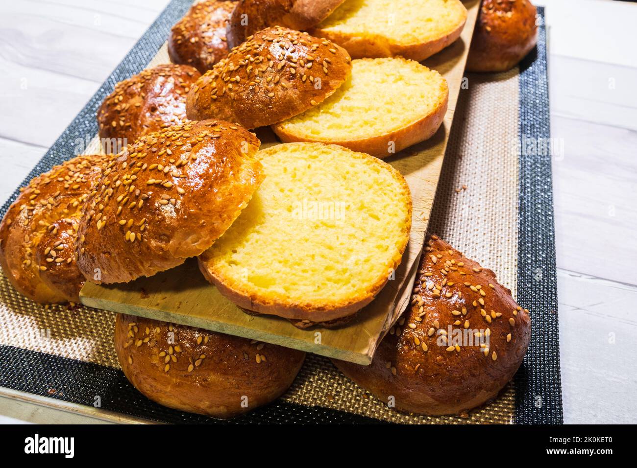 freshly baked buns cut to make pulled pork hamburger Stock Photo - Alamy