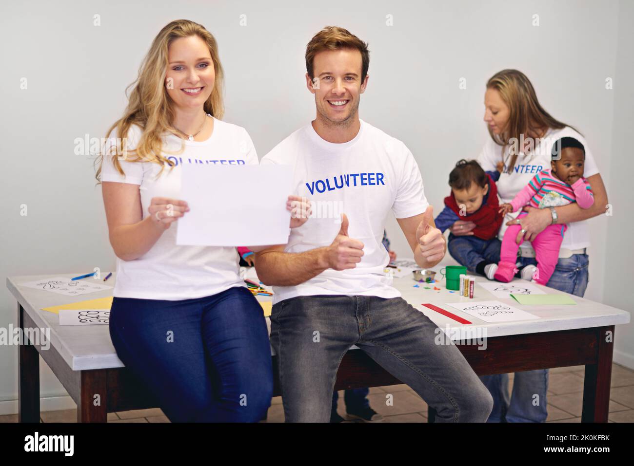 You can help too. Portrait of volunteers holding up a blank sign while ...