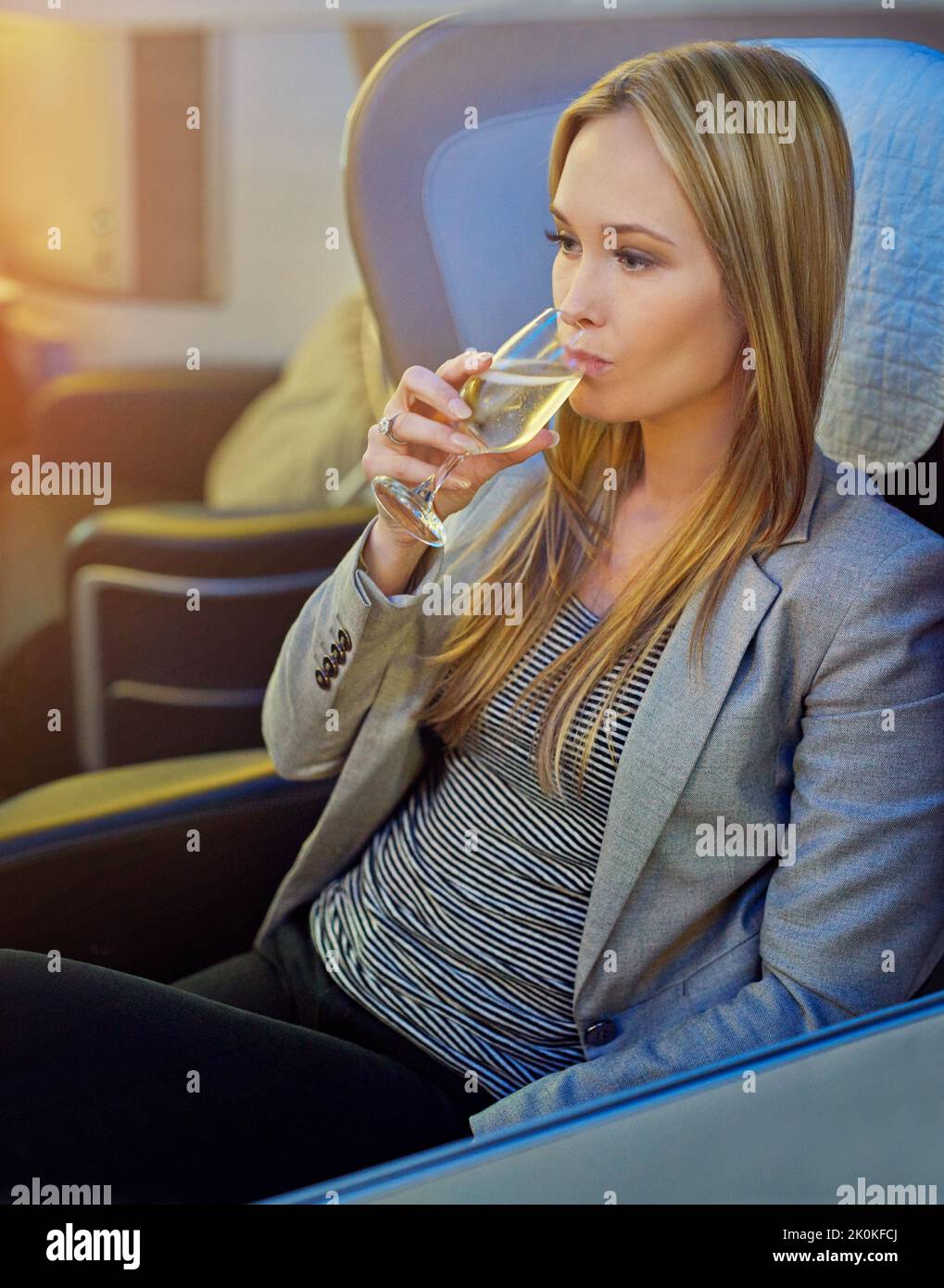 Its the only way to fly. a young woman drinking champagne in first ...
