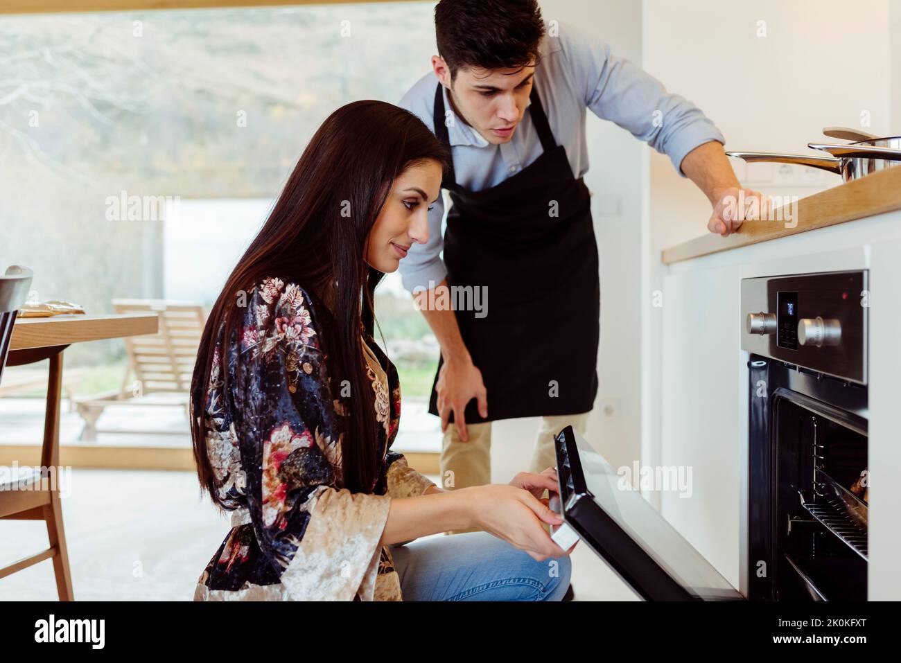 Side view of attractive couple cooking in a modern kitchen Stock Photo ...