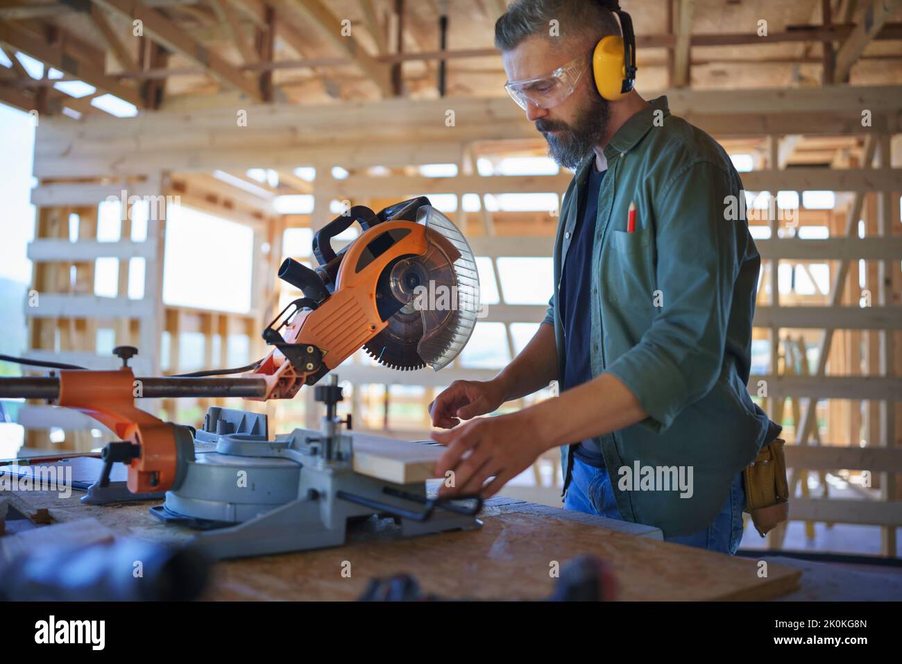 Construction worker working with eletric saw inside wooden construction ...