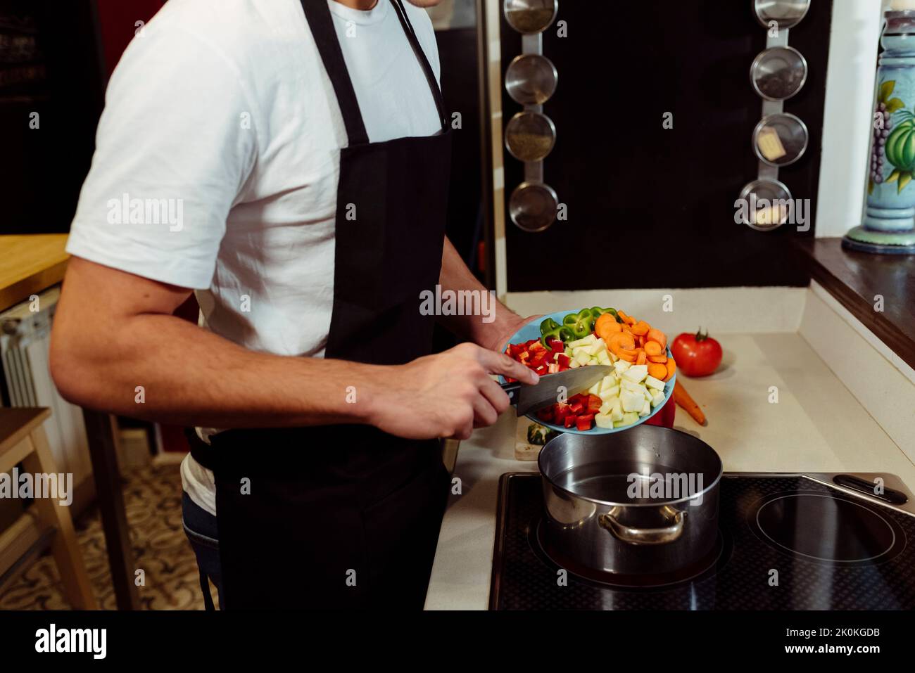 Side view of cropped unrecognizable male cook with apron putting ...