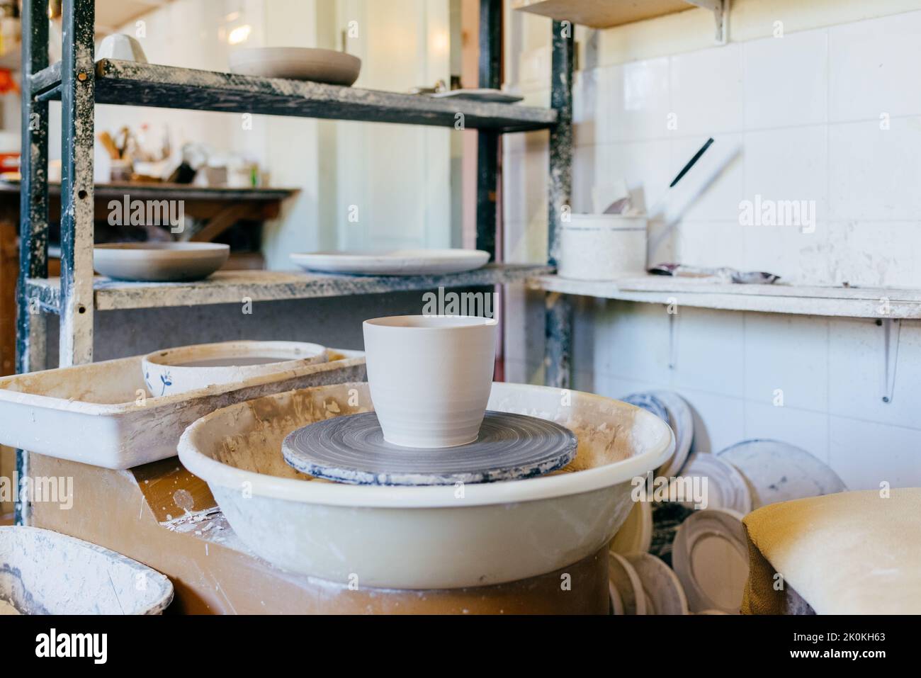 Clay pot left on pottery wheel after shaping process in creative ...