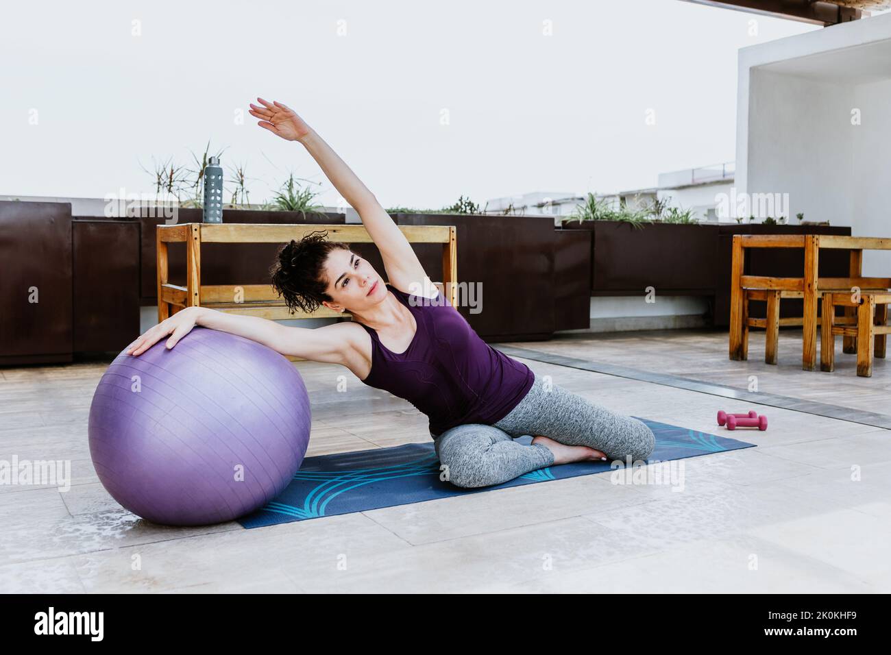 Full body of concentrated fit young female athlete in activewear doing ...