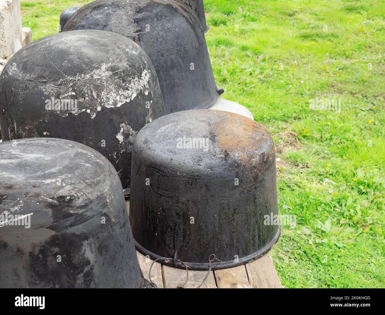 Empty cauldrons in nature. Blackened outdoor picnic cauldrons. Charred ...