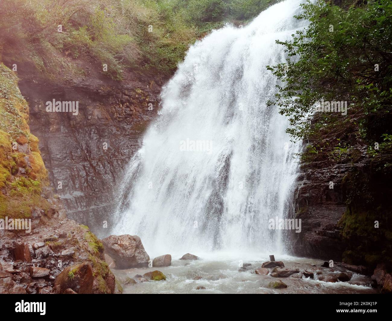 Stormy waterfall in a green mountain forest on a cloudy day Stock Photo ...