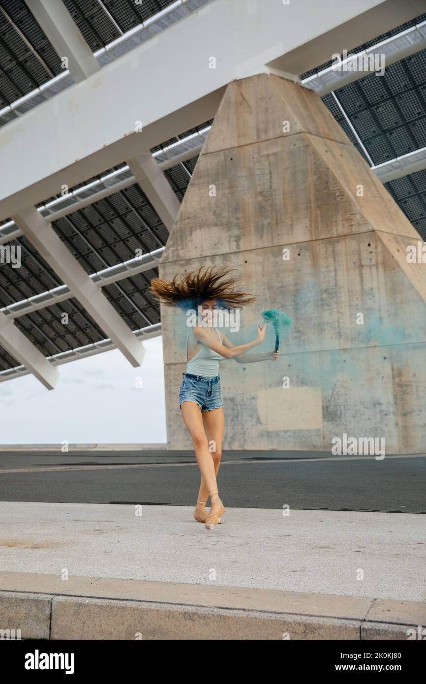 Woman holding colorful smoke bomb dancing ballet outdoors Stock Photo ...