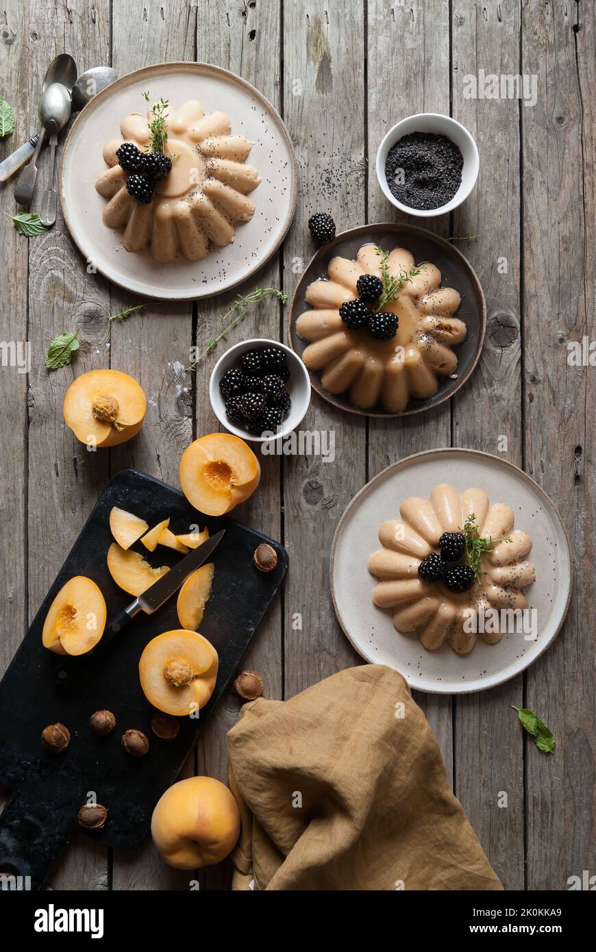 Flat lay of arranged served panna cotta with peach and poppy seeds on ...