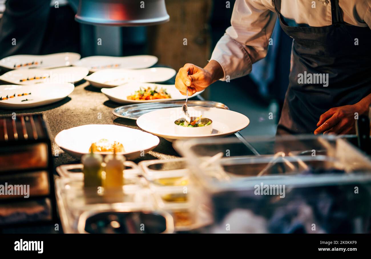 Crop professional chef pouring sauce on dish in elegant plate working ...