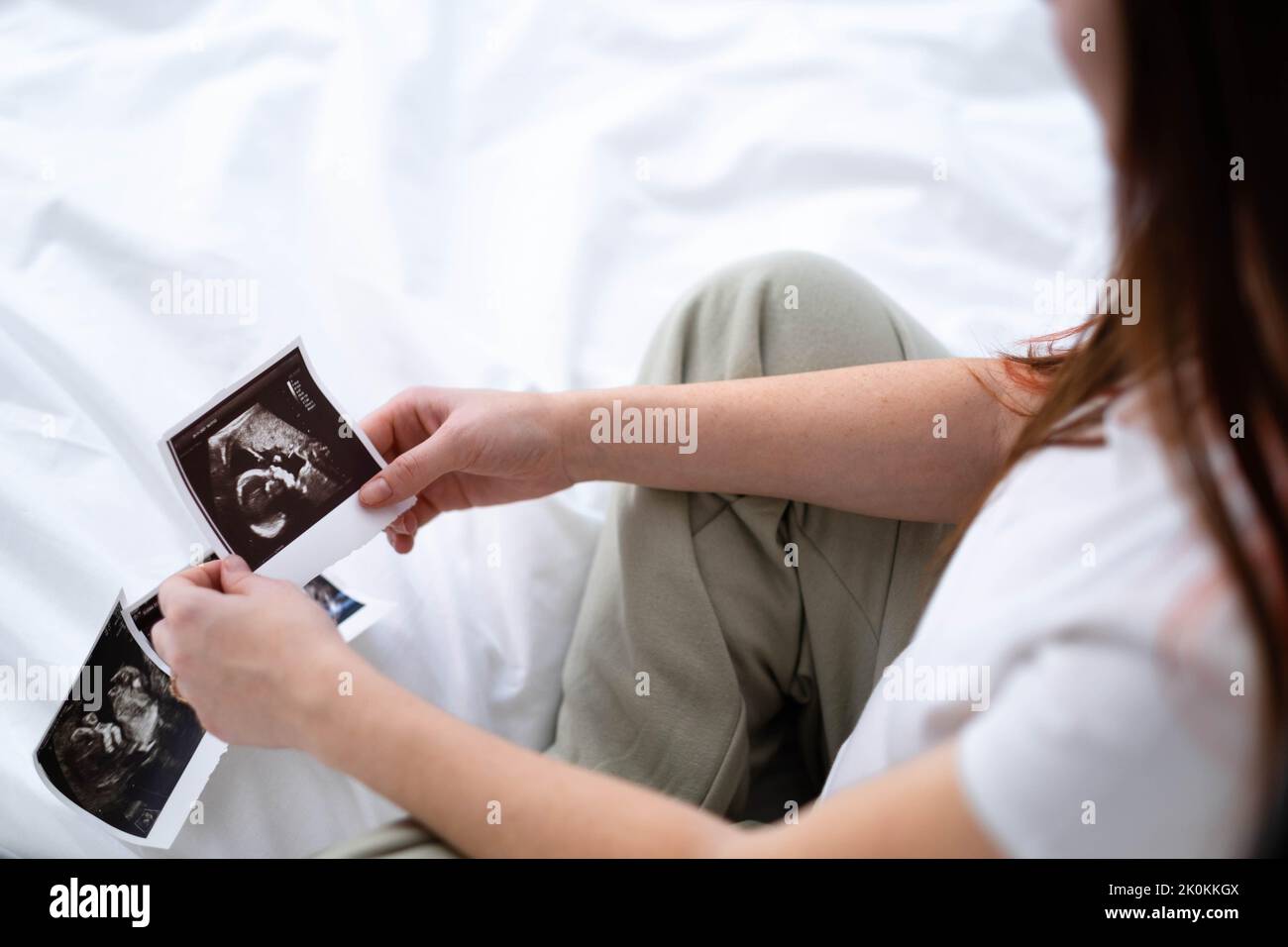 Top view cropped of pregnant woman looking ultrasound photo of fetus ...