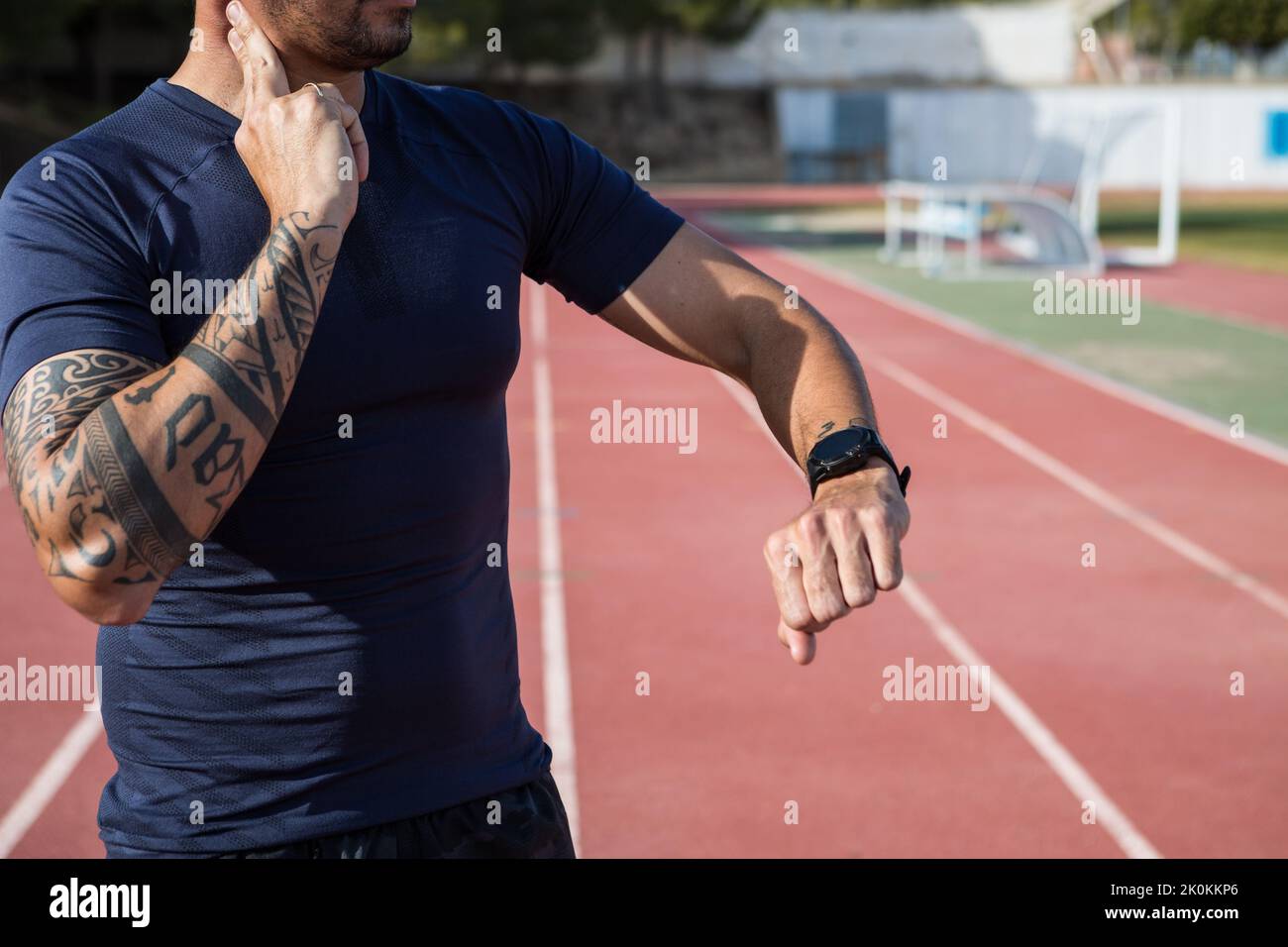 Crop unrecognizable male runner checking pulse on neck and watching at ...