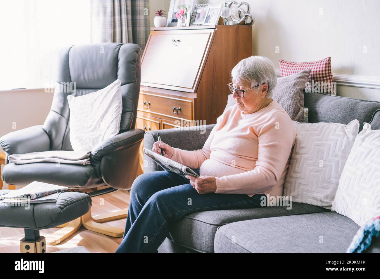 Old senior woman, 80s adult, grandmother, making crossword puzzles in ...
