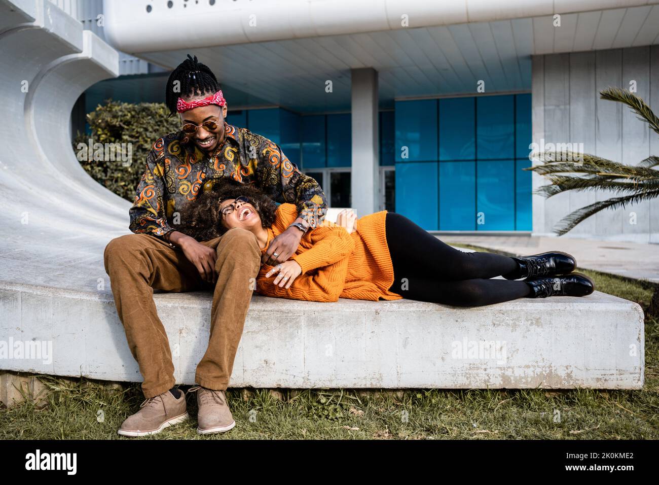 Happy black man and woman in stylish casual outfits cuddling on ...