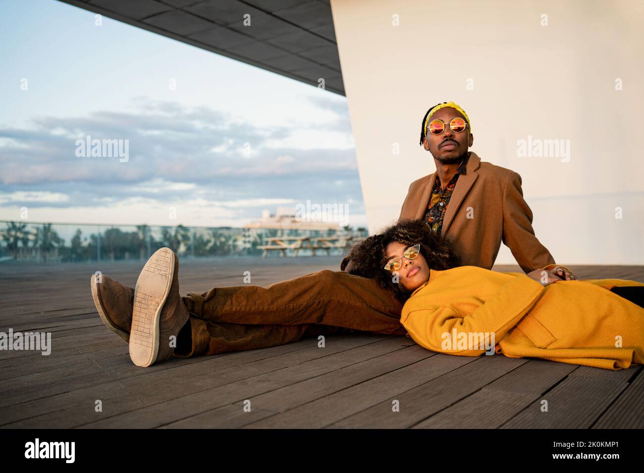 Loving black man with dreadlocks sitting with charming girlfriend lying ...