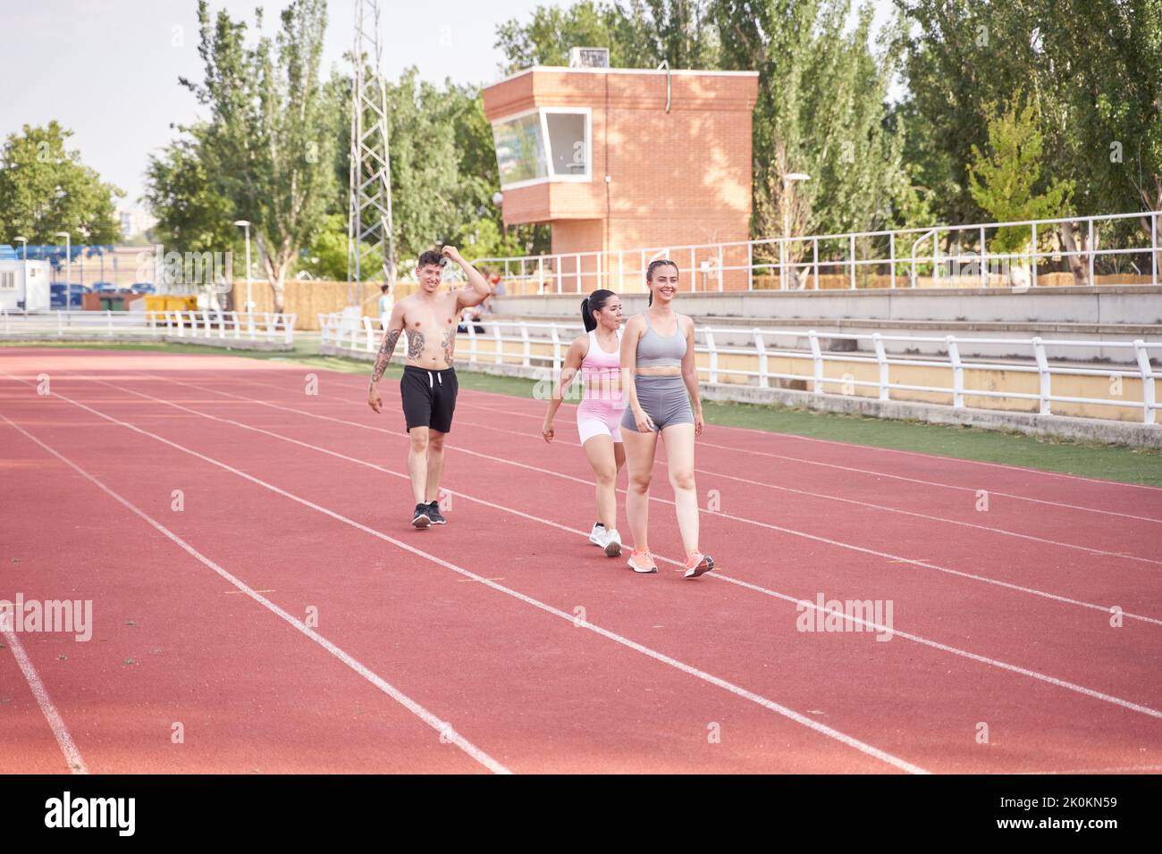 three people walking athletics track Stock Photo - Alamy