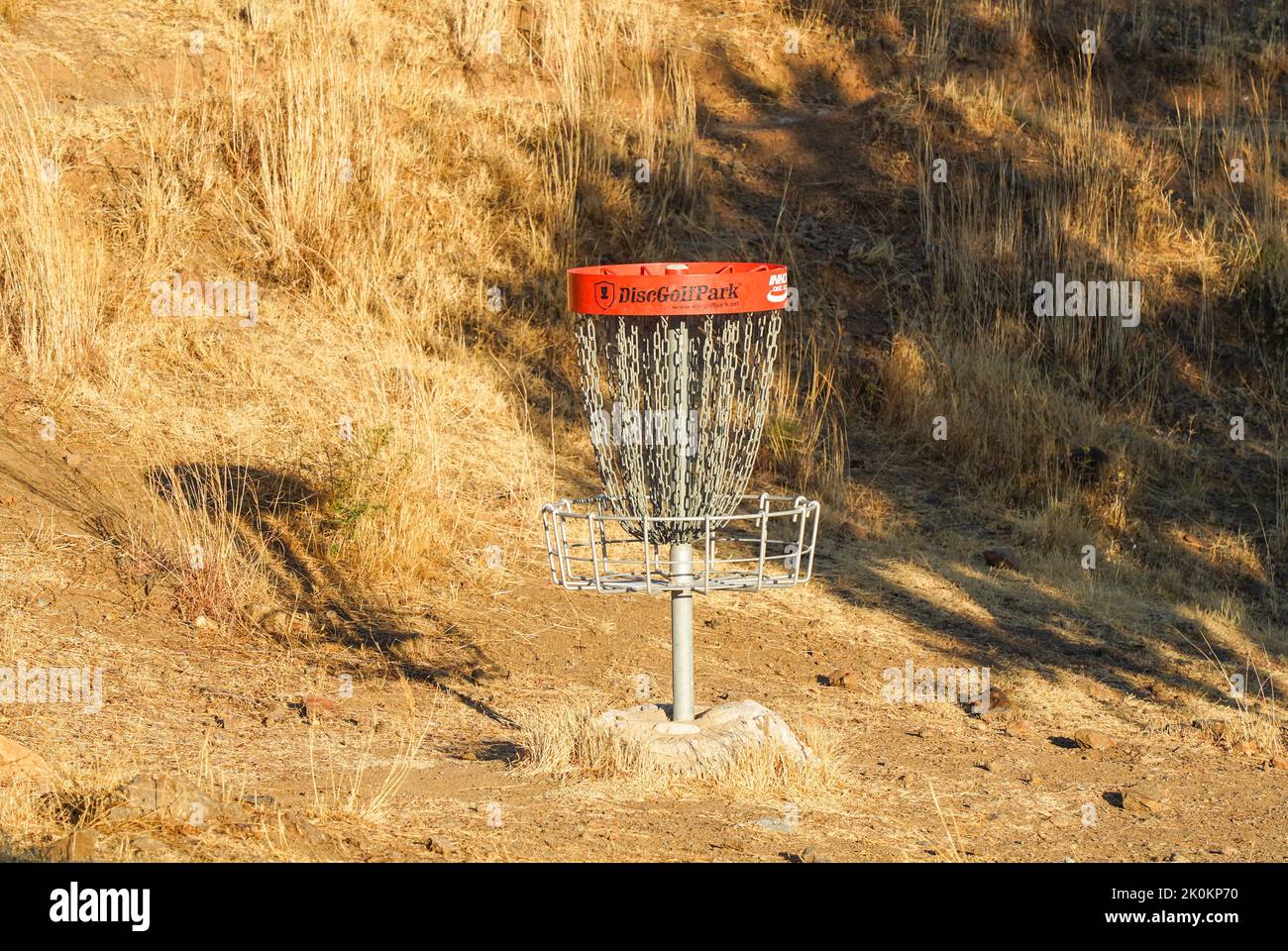 Disc golf basket target on dry grassy hillside, Spain Stock Photo - Alamy