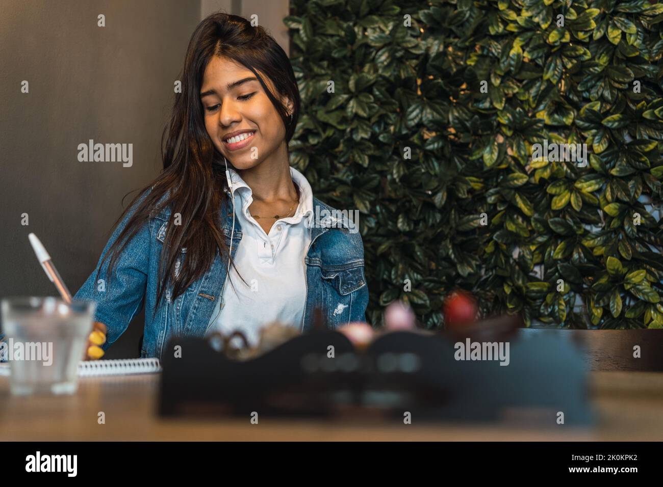 Content smart young Hispanic female student reading textbook and ...