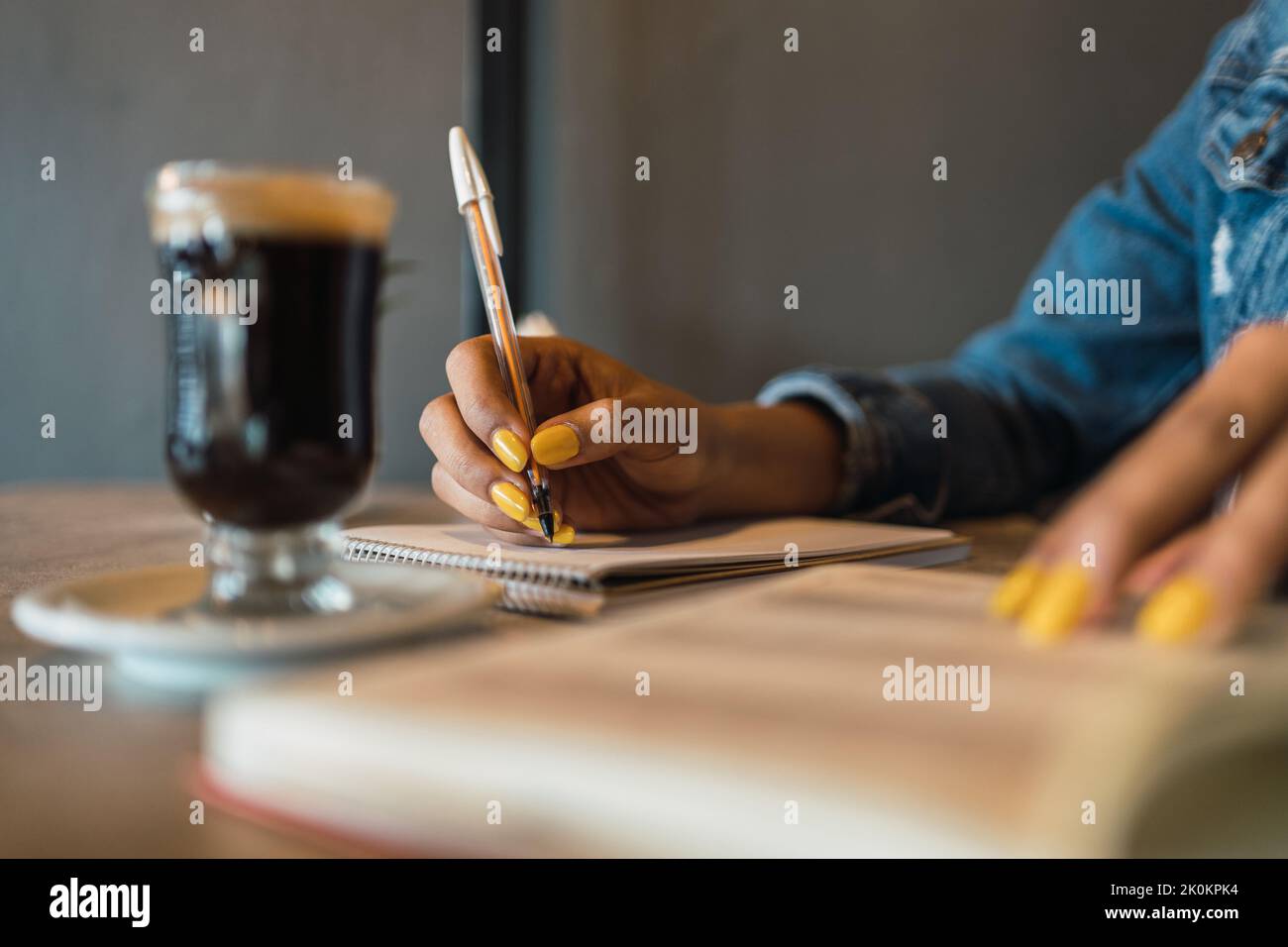 Cropped unrecognizable hispanic female student writing in copybook ...