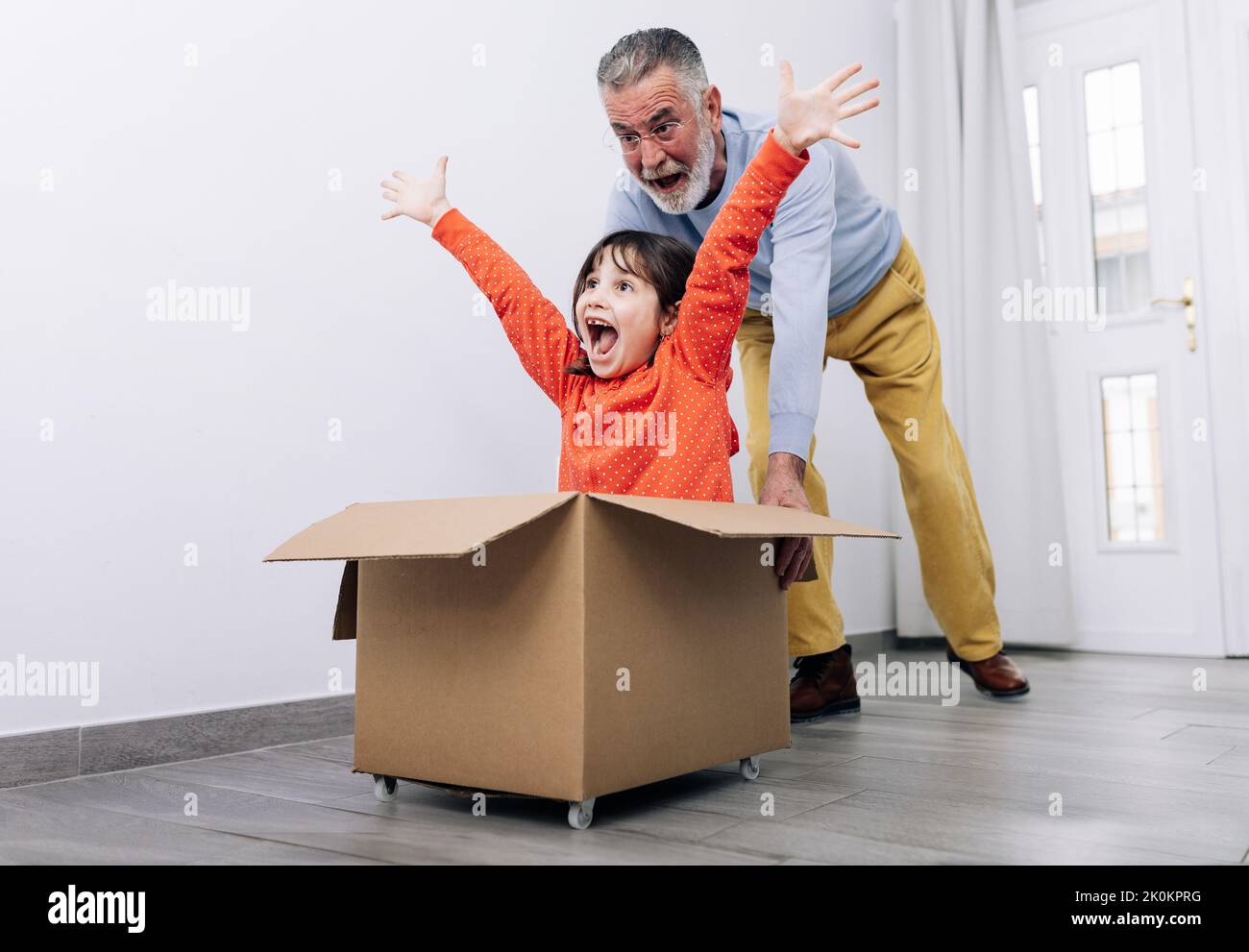 Happy kid and casual clothes pretending to be racer while sitting in ...