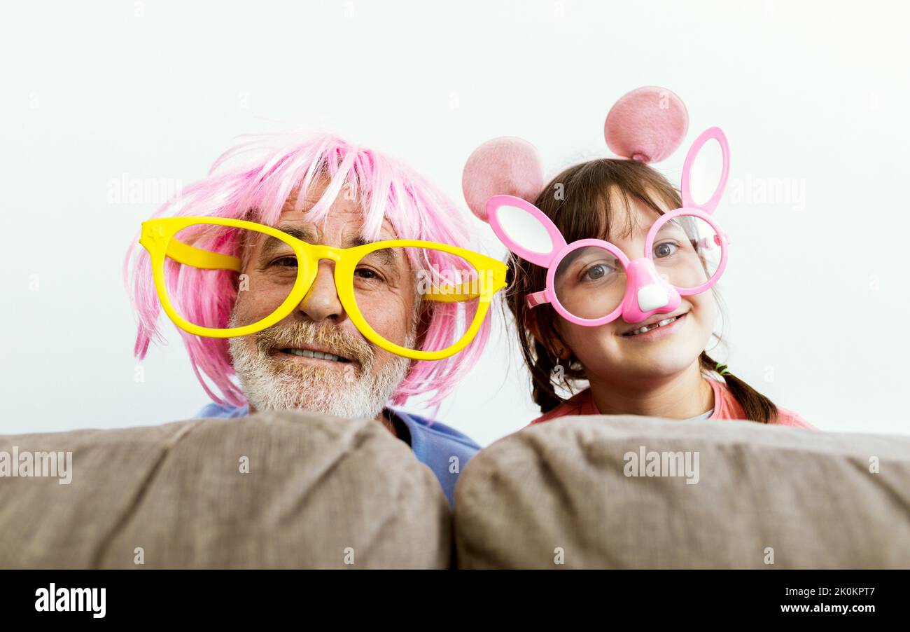 Happy child sitting on couch with grandfather in big pink plastic ...