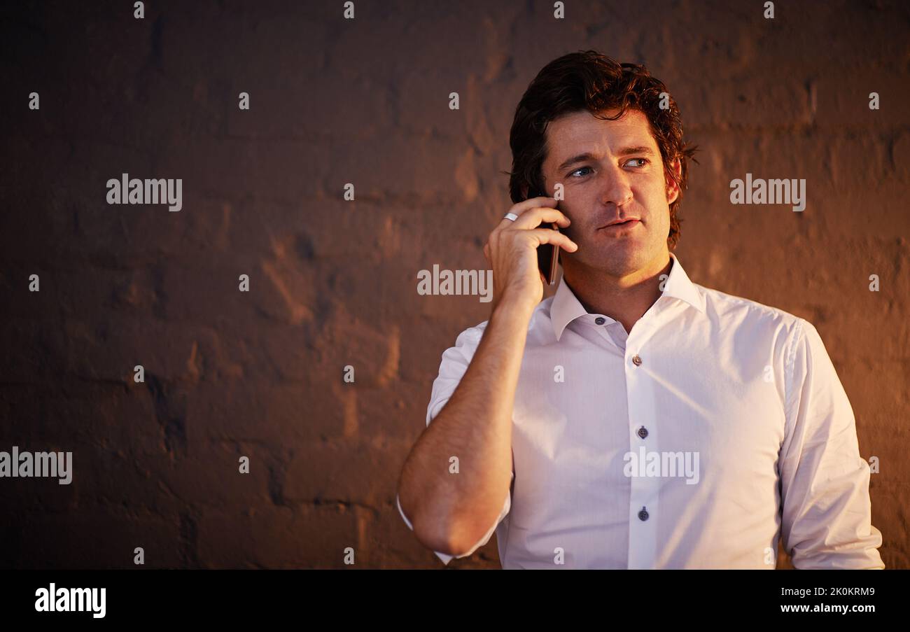 Staying in touch with his clients. a businessman making a phone call ...
