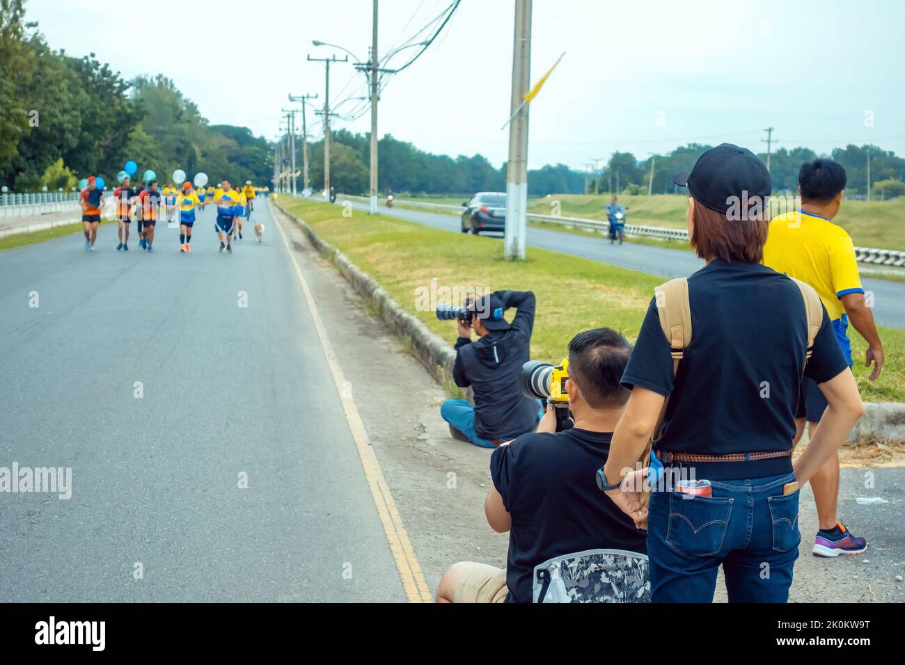 Back view of Asian sport photographer with camera sit to take picture ...