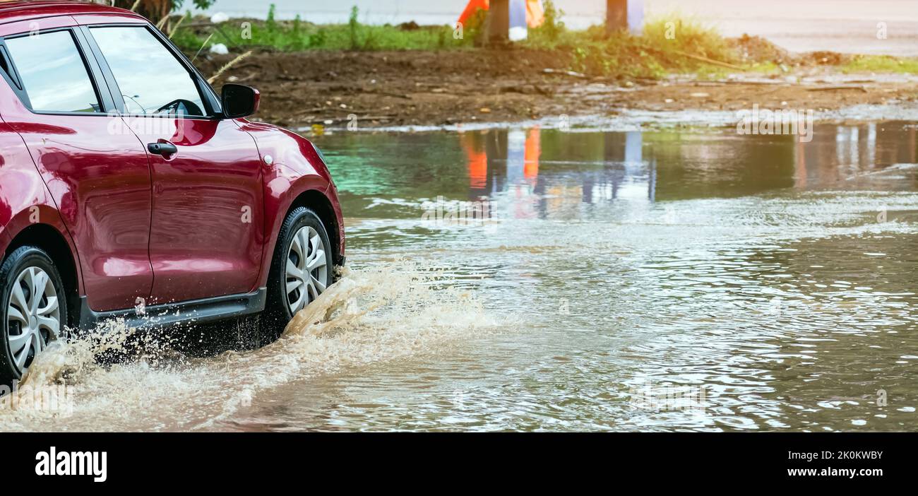 Car passing through a flooded road. Driving car on flooded road during ...
