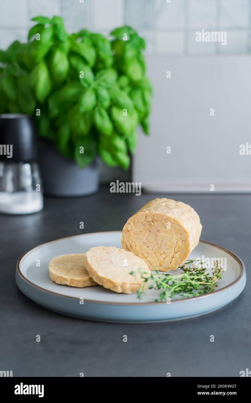 Raw Tempeh or Tempe, made of fermented soybean seeds on kitchen table ...