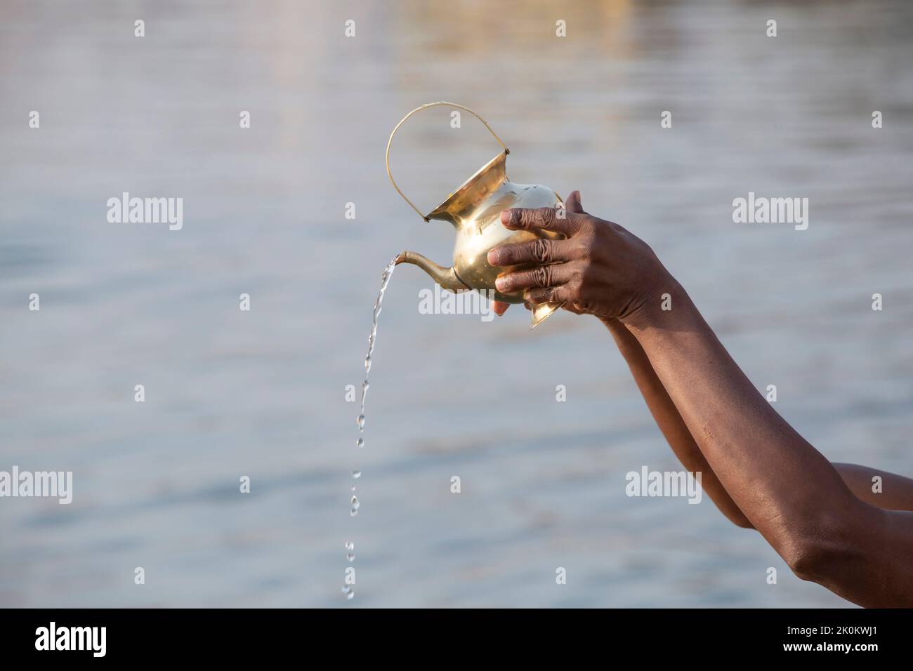 close up of hands of hindu performing morning puja ritual at Ganges ...