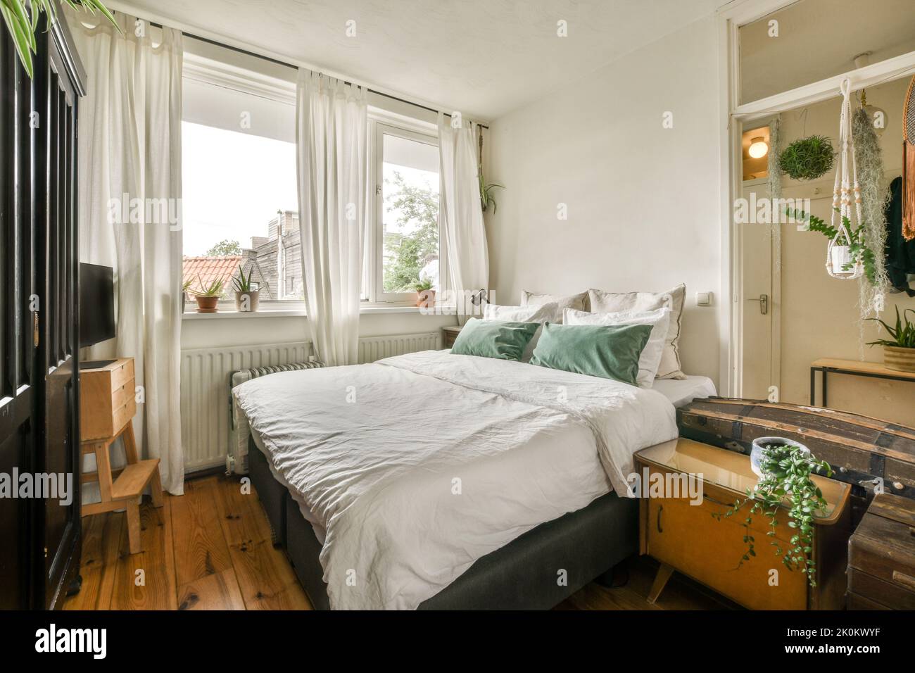 Retro bedside table and lamp located near comfortable bed and shelf ...