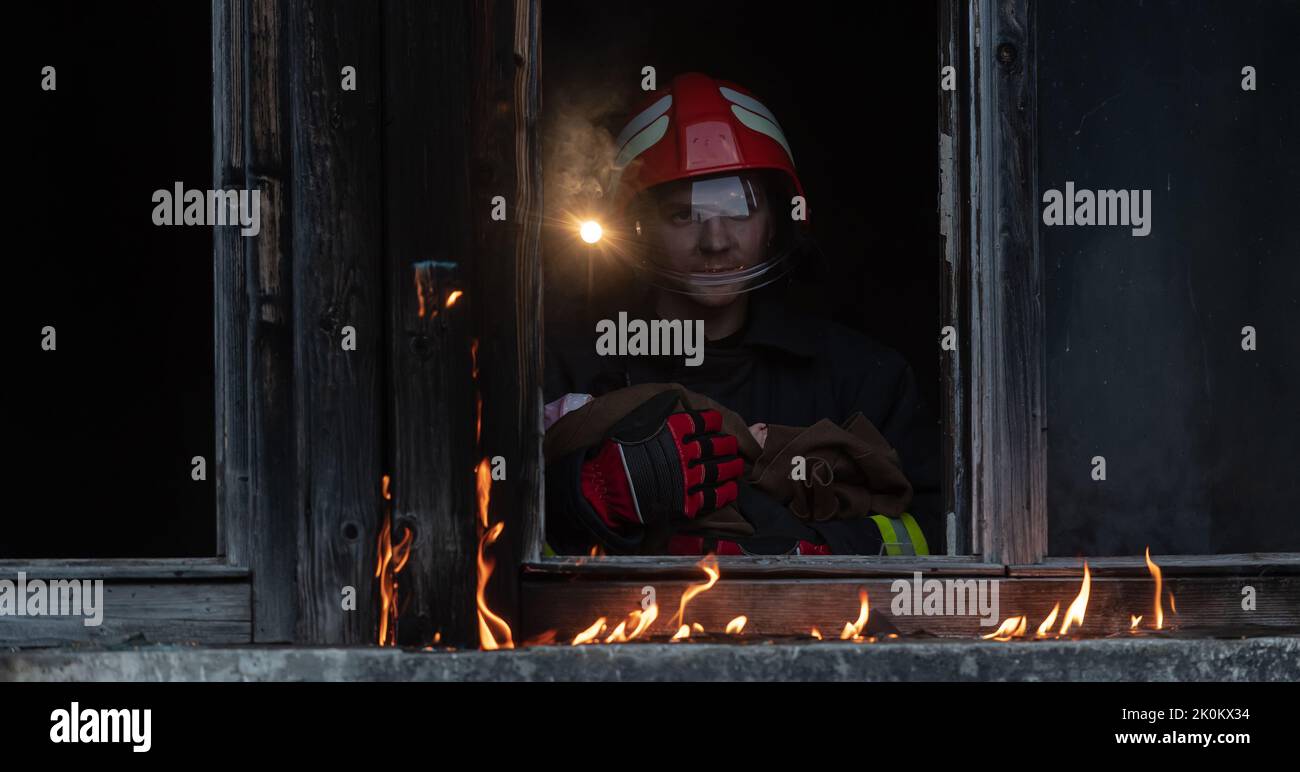 Firefighter hero carrying baby girl out from burning building area from ...