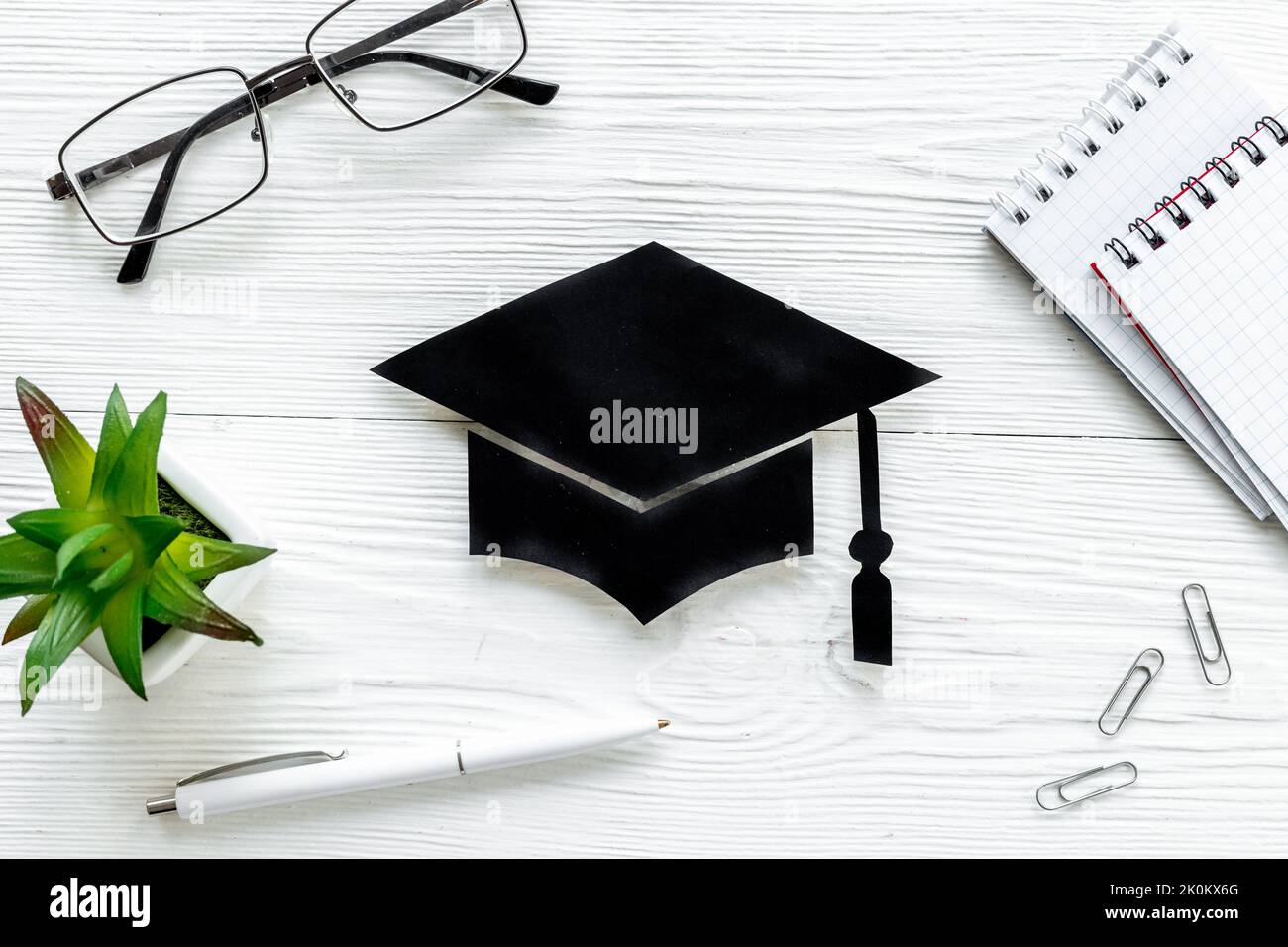 Black academic cap or graduation hat on students table, top view Stock ...