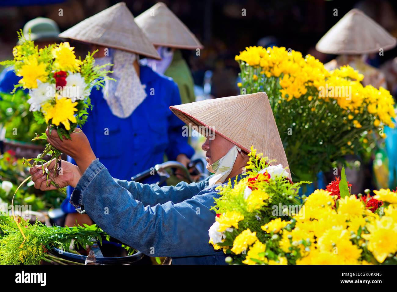 Vietnamese vendor wearing bamboo hat working in open air street market ...