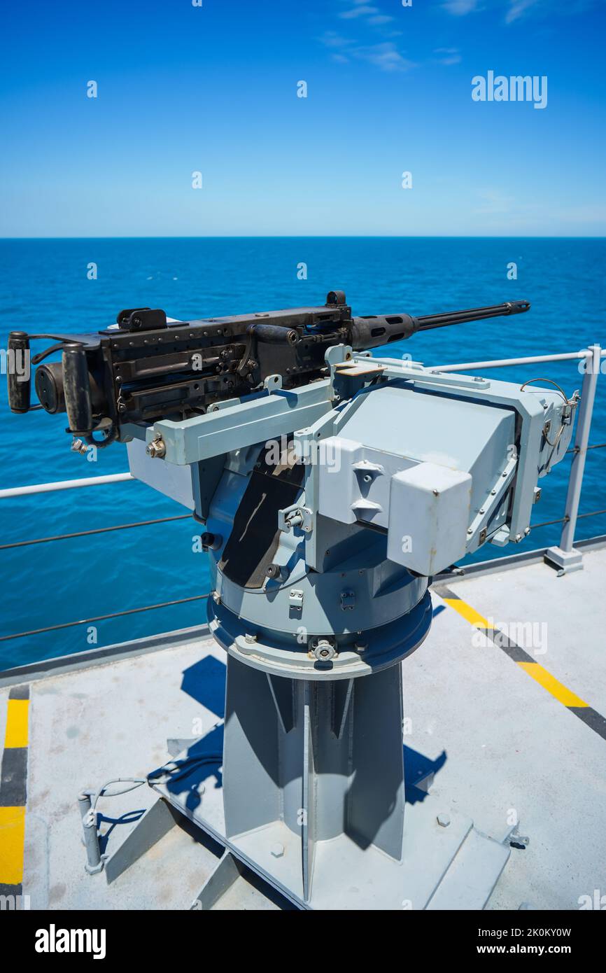 Color image of an automated machine gun on the deck of a military ship ...