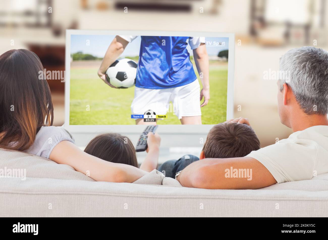 Caucasian family sitting on the couch and watching football match Stock ...