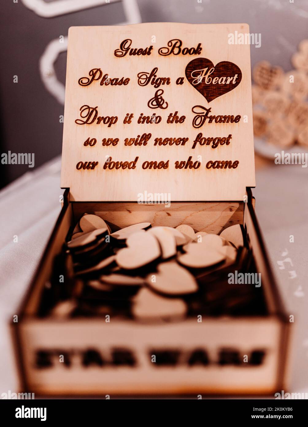 A closeup shot of a wooden guest wish box full of hearts for a wedding ...